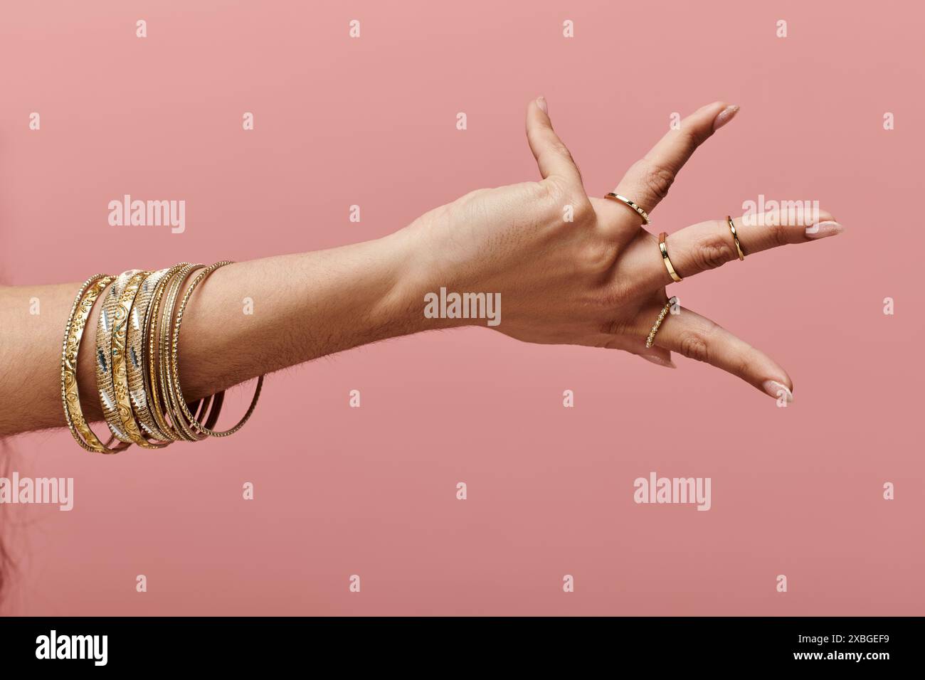 indian woman showcasing gold bangles on her hand in a stylish pose ...