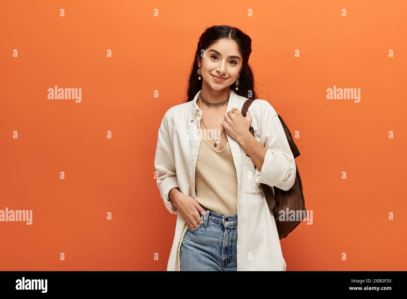 Stylish young indian woman posing confidently in white shirt and jeans ...