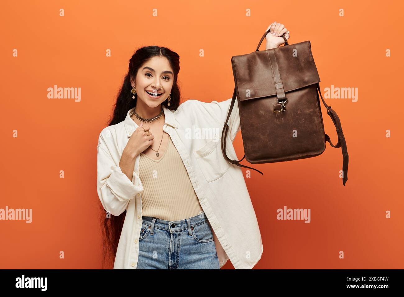A young indian woman with a brown backpack strikes a graceful pose ...