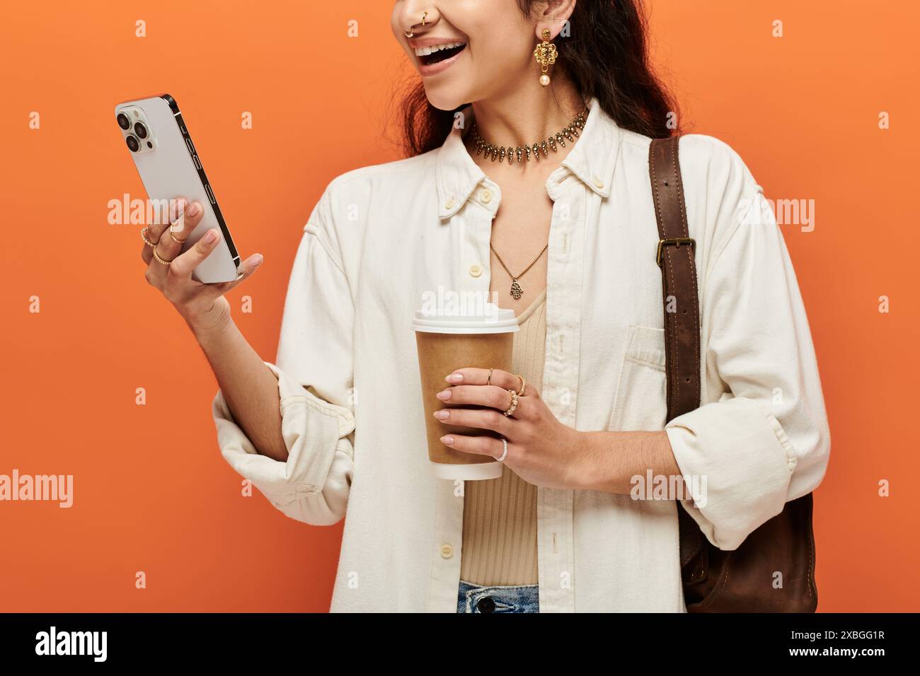 Young indian woman multitasking with coffee and phone in hand Stock ...