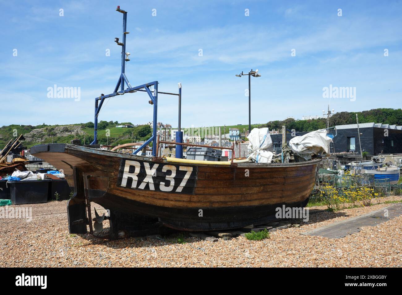 Rustic wooden fishing boat RX37 on The Stade Beach under a blue sky ...