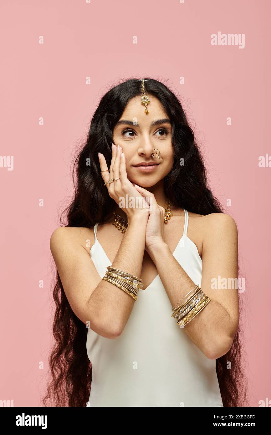 Young indian woman with long hair striking a serene pose with hands on ...