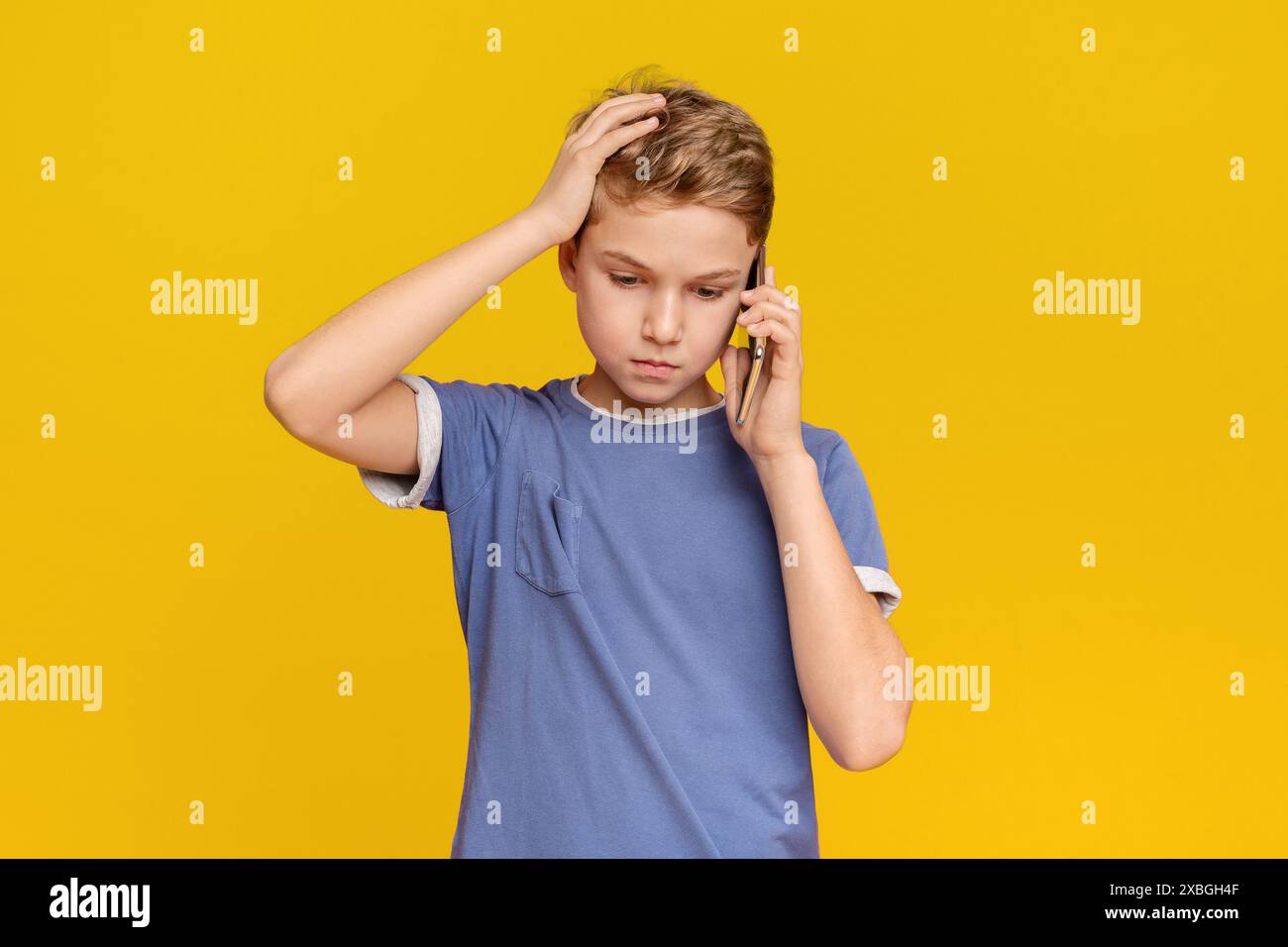 Teenage boy talking on phone, holding hand on head in stress Stock ...