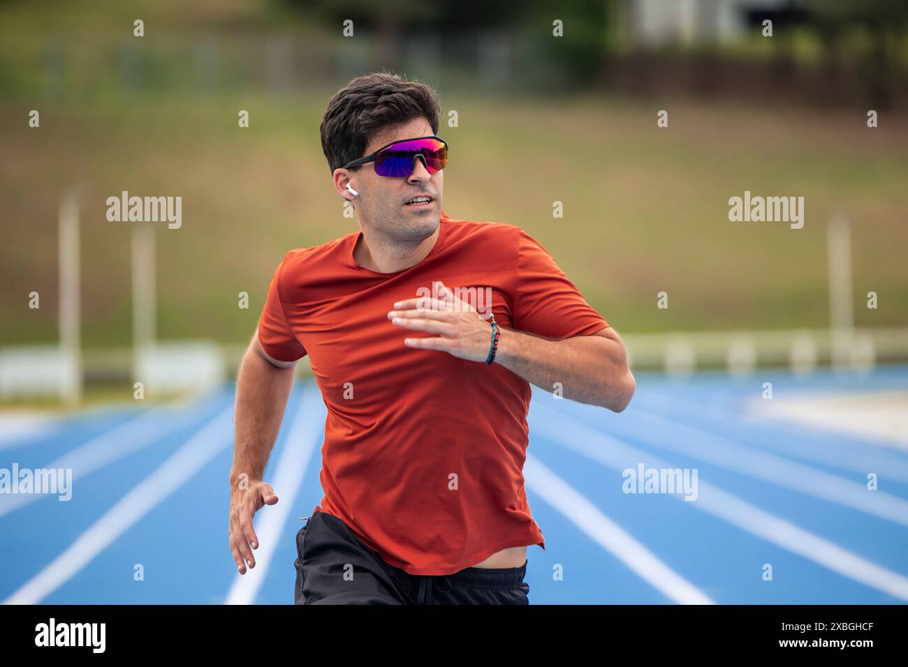 closeup male runner wearing wireless earphones and sunglasses is ...