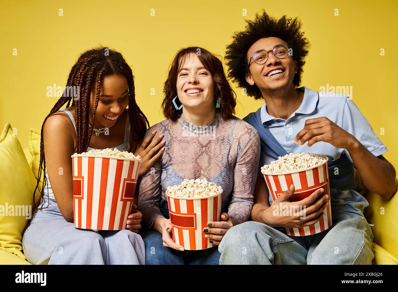 A diverse group of friends in stylish attire sitting on a couch ...