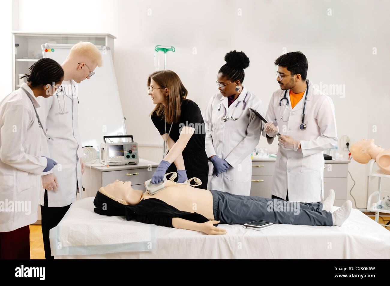 A group of medical students practice CPR on a mannequin in a classroom ...