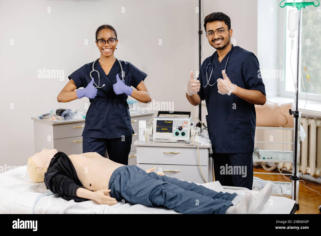 Two medical students practice CPR on a mannequin in a hospital room ...