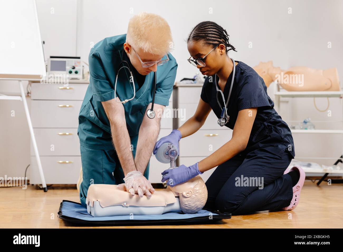 Two medical professionals practice CPR on a training mannequin ... Two medical professionals practice CPR on a training mannequin ...