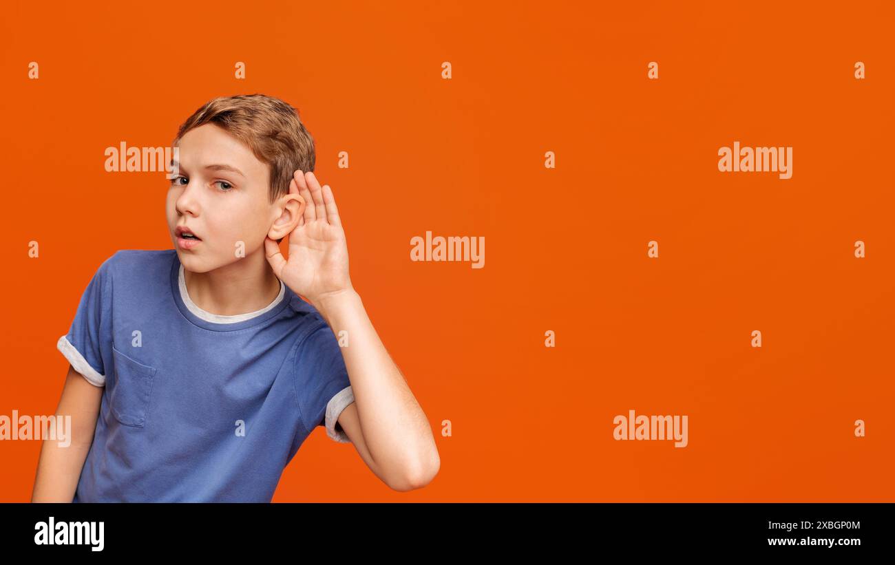 Curious snoopy schoolboy holding hand at his ear Stock Photo - Alamy