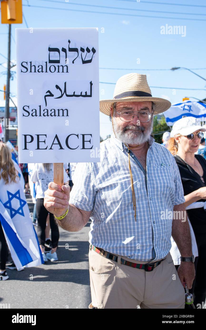 Man holds sign with word “peace” in Arabic and Hebrew during UJA ...