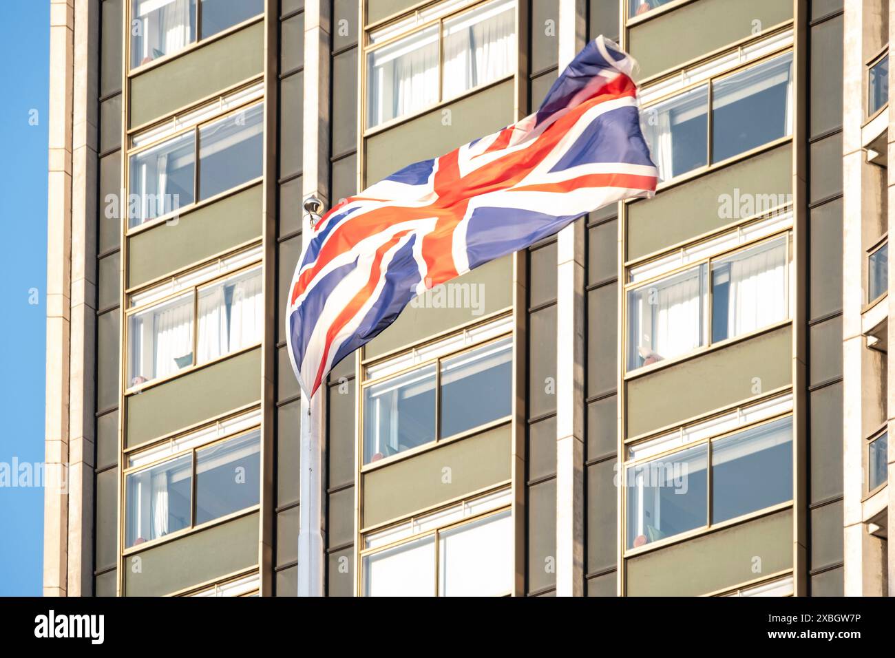 blurred Flags United Kingdom flutter against backdrop building facades, international friendship ...