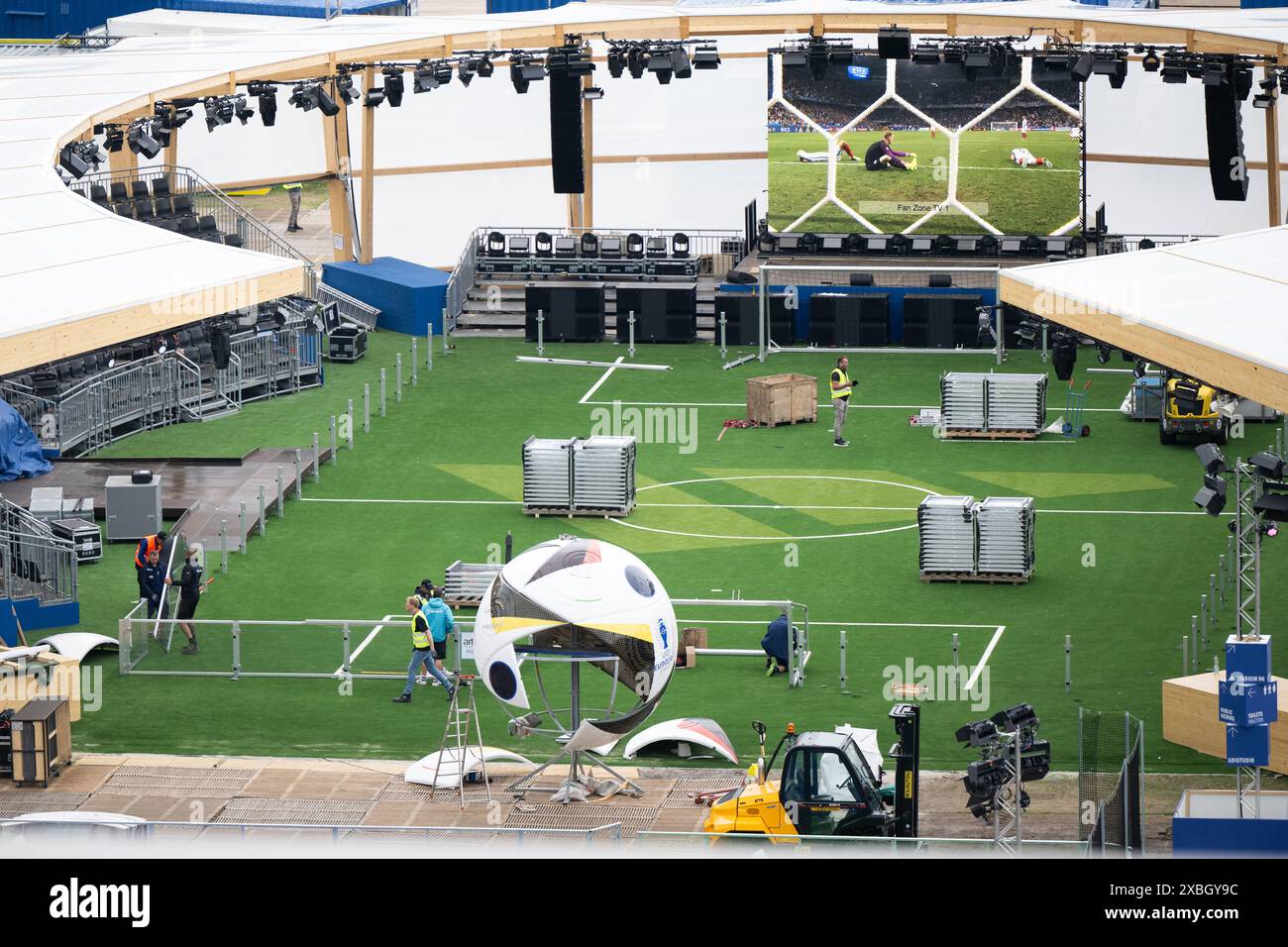 12 June 2024, Berlin: Workers set up the temporary stadium "Home of ...