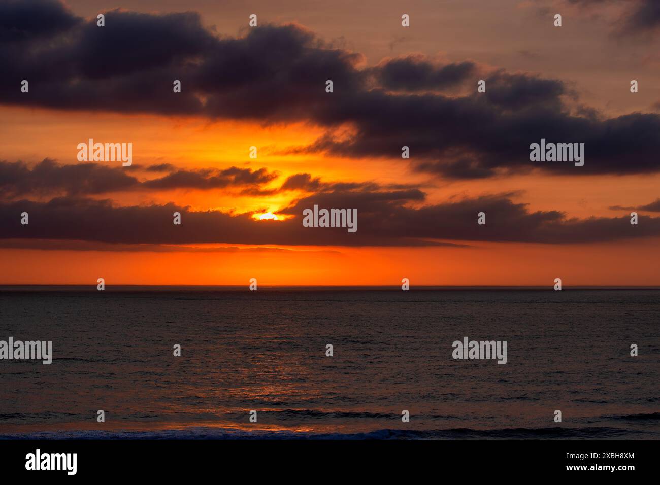 Sun rising in cloudy skies over the Atlantic Ocean at Nags Head, in ...