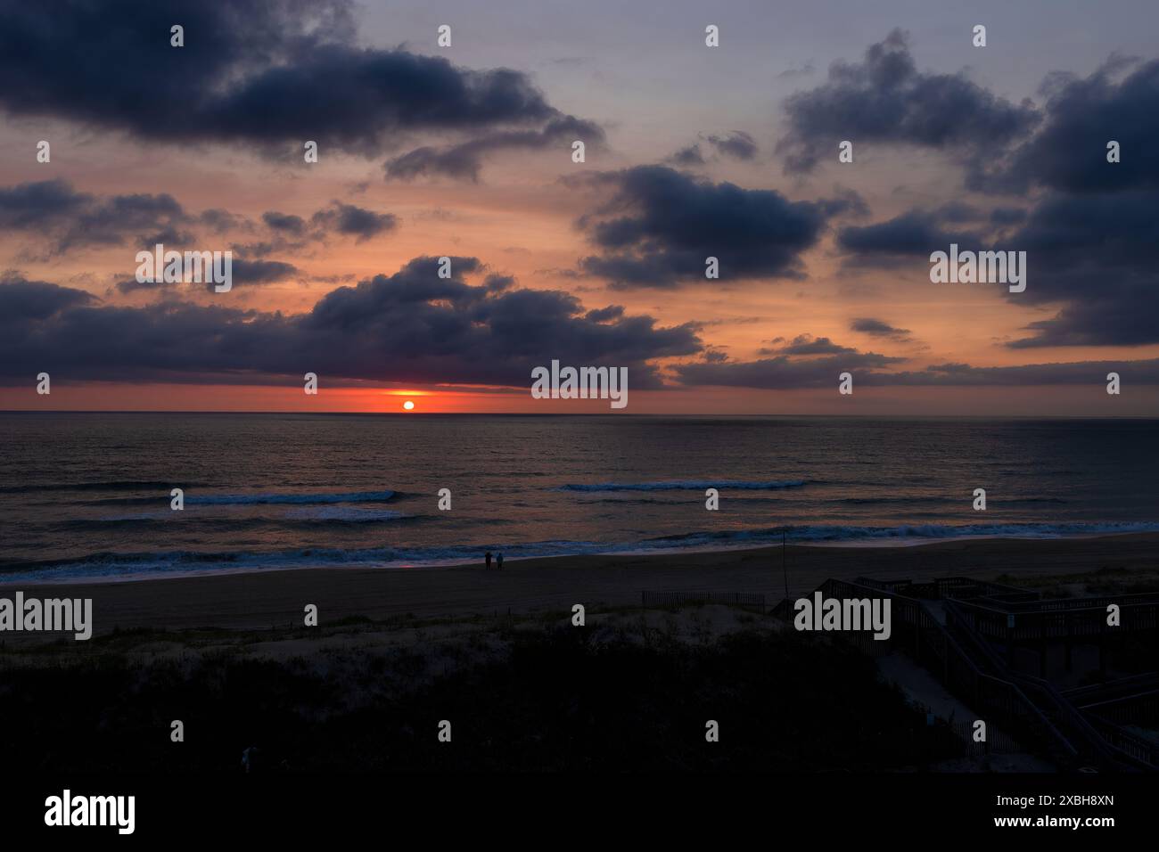 Sun rising in cloudy skies over the Atlantic Ocean at Nags Head, in ...