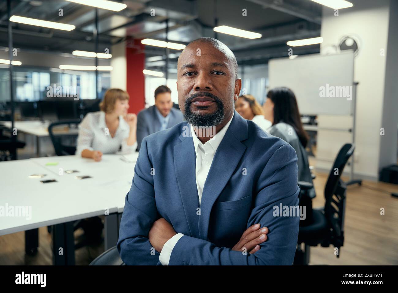 Five multiracial adults in businesswear during discussion around ...