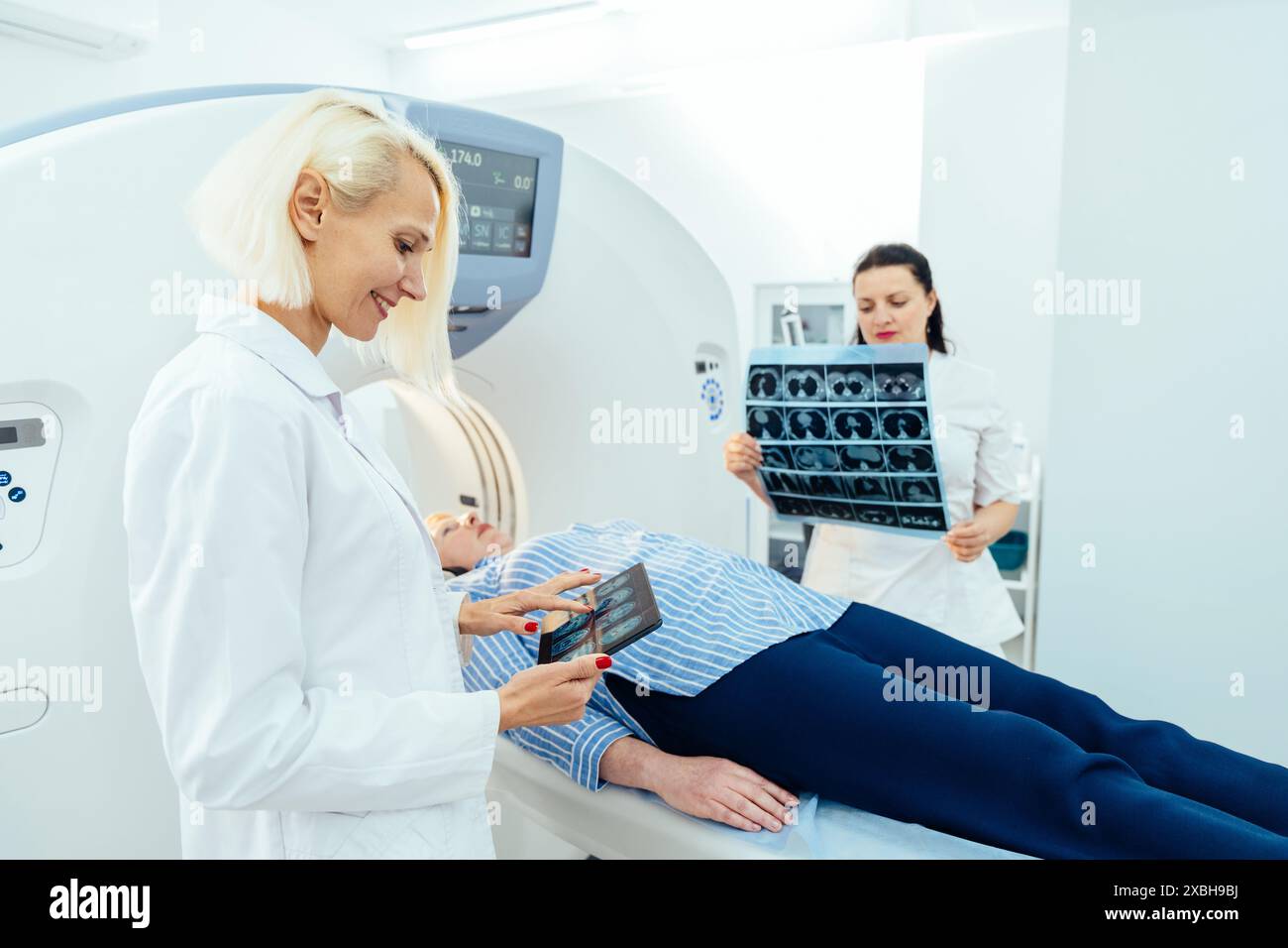 Doctor examining X-ray images on display in MRI control room while in ...