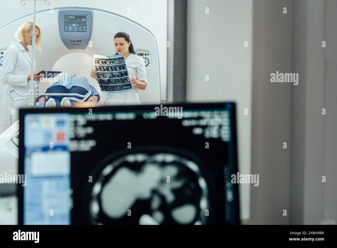 Doctor examining X-ray images on display in MRI control room while in ...