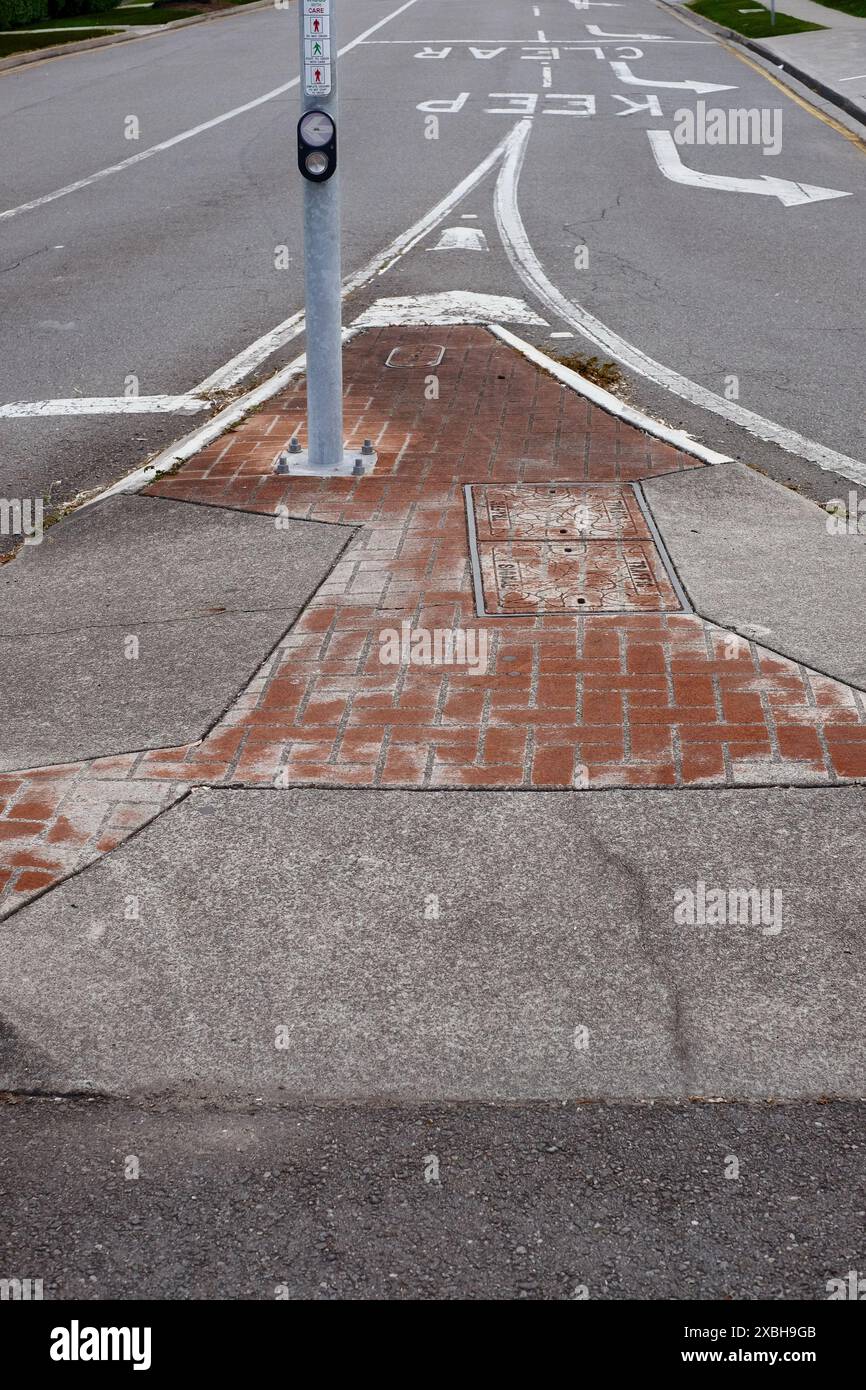Pedestrian island with walk button on traffic light pole, concrete ...