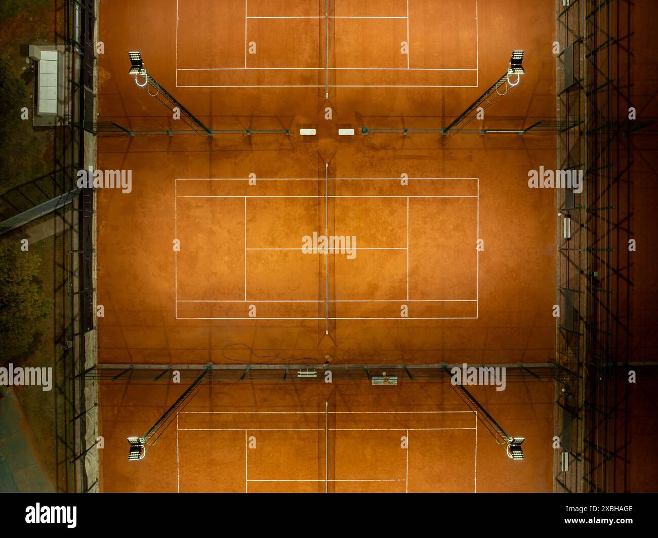 A tennis court with three courts and a few lights. Aerial view Stock ...