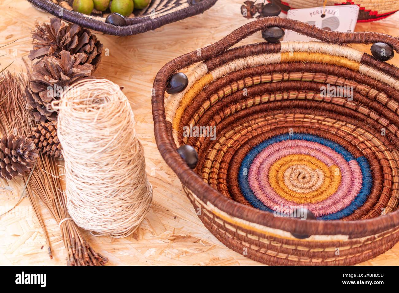 overhead view of a still life with a colorful handmade basket made of ...