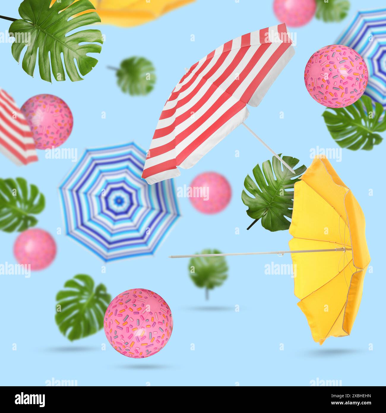 Summer party. Beach umbrellas, balls and tropical leaves in air on ...
