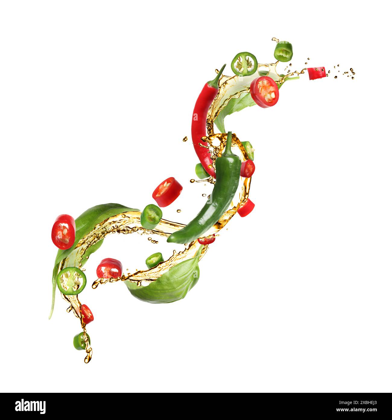 Cooking oil splash with chili peppers and basil in air on white ...
