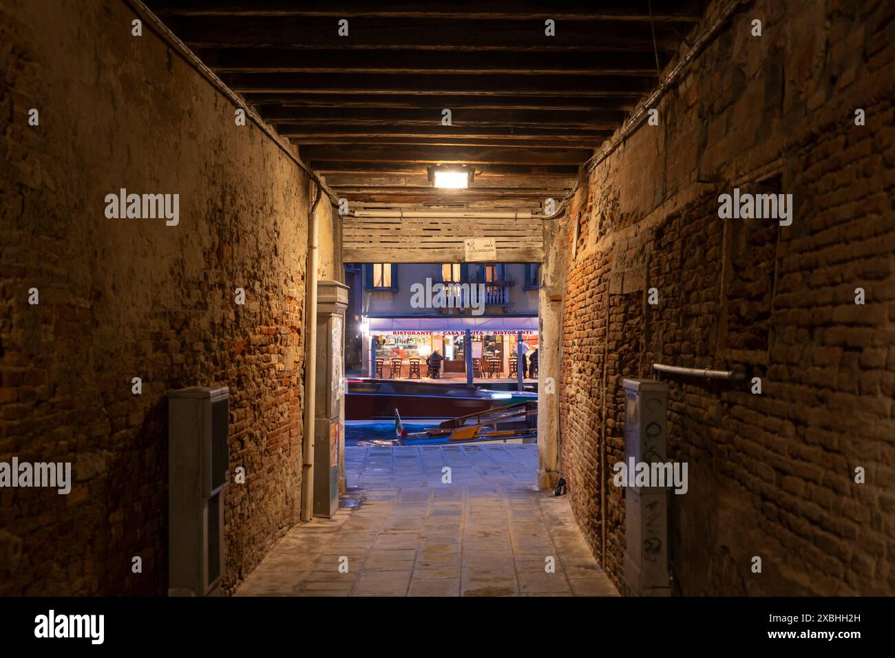 City of Venice, Italy, old passageway with aged brick walls and wooden ...
