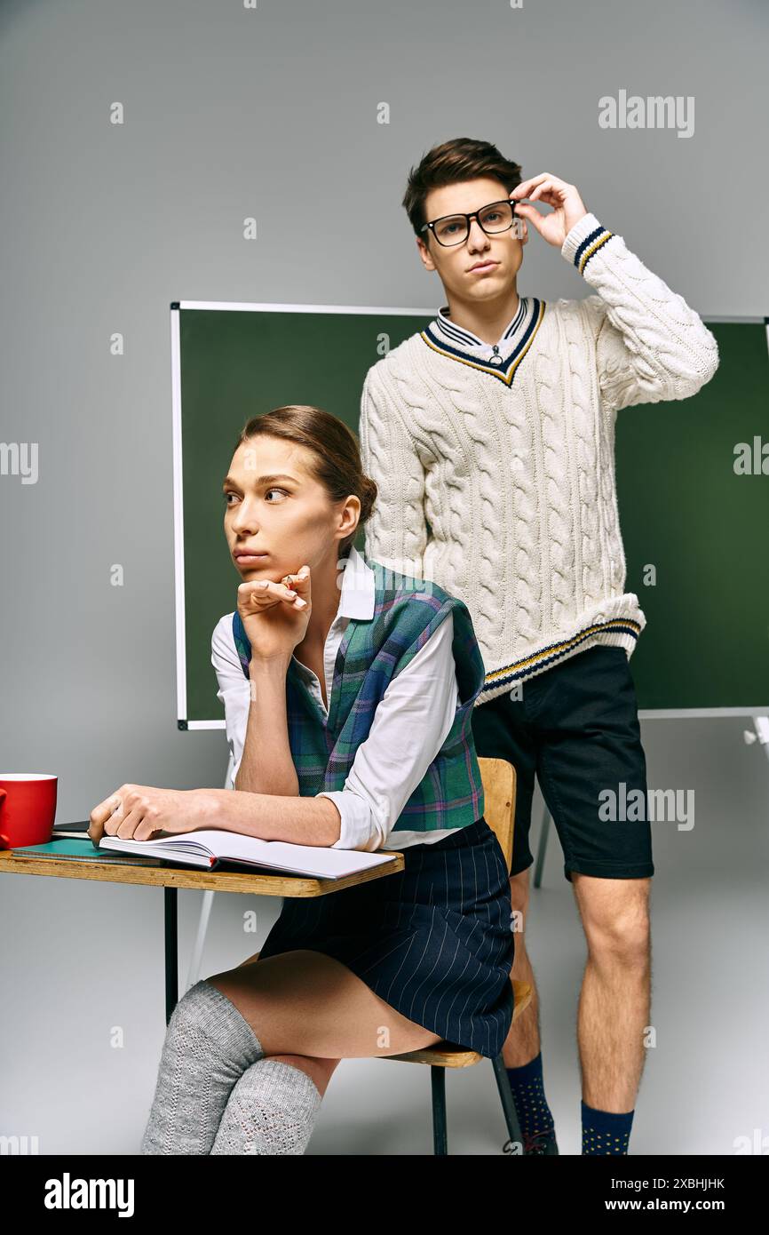 A stylish man and woman interacting by a green board Stock Photo - Alamy