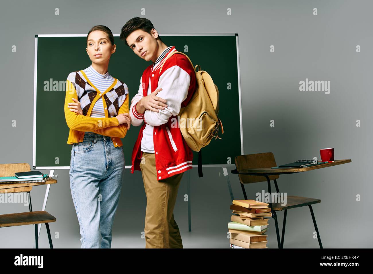 Two stylish students stand confidently before the green board in a ...