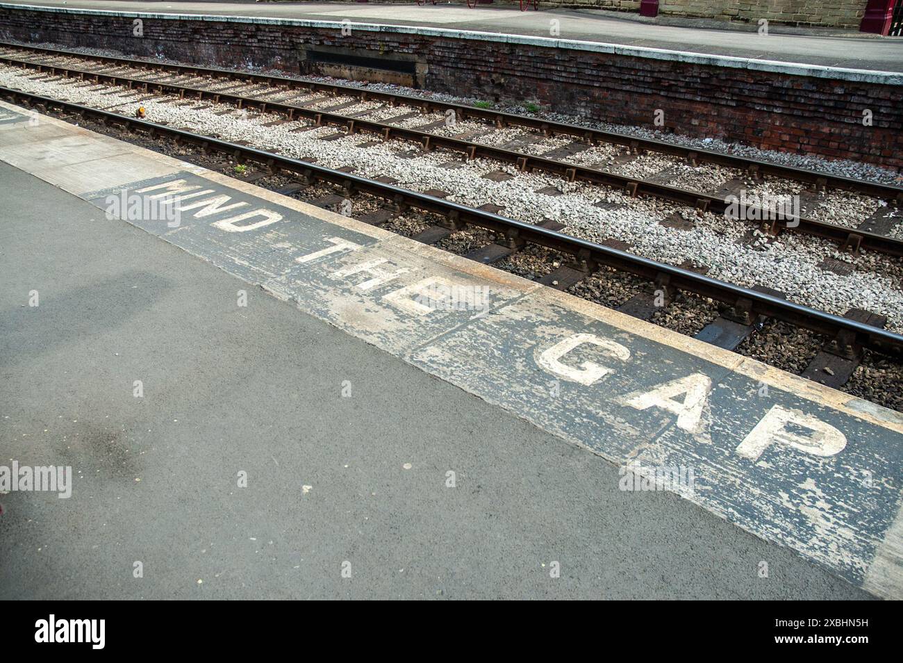 MInd the gap at the platform edge signage at a train station in ...