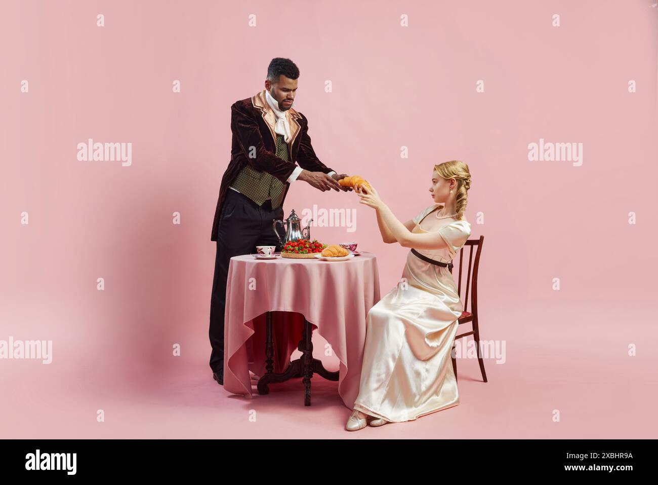 Common breakfast. Handsome man and leant woman in renaissance attire ...