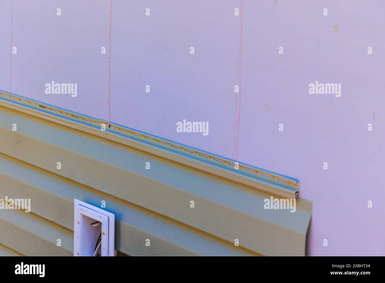 New home wall facade is covered with vinyl plastic siding panels ...