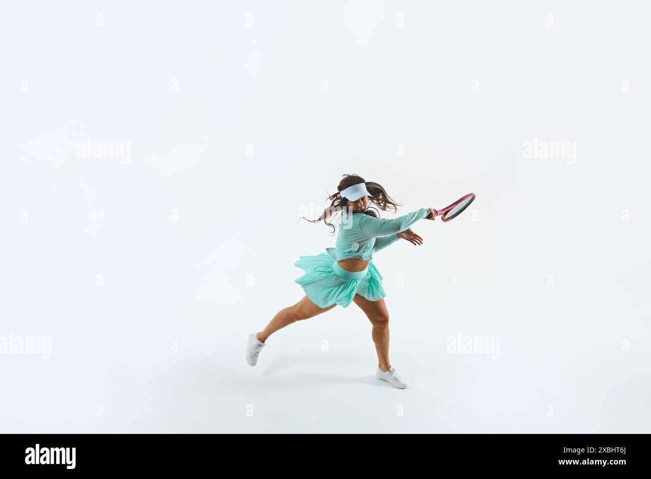 Athletic female tennis player in mint-green outfit performs forehand ...