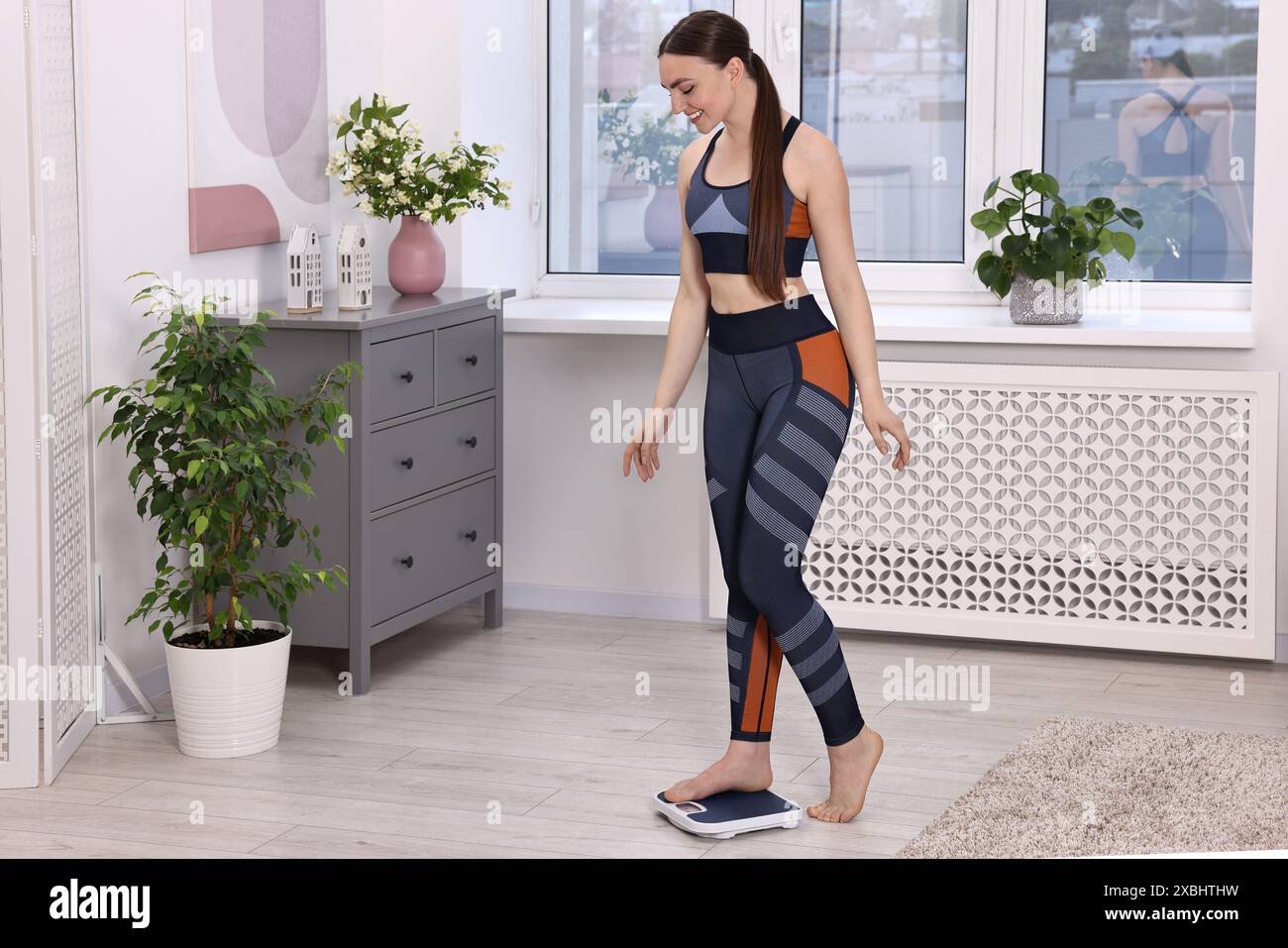 Woman stepping on scale hi-res stock photography and images - Alamy