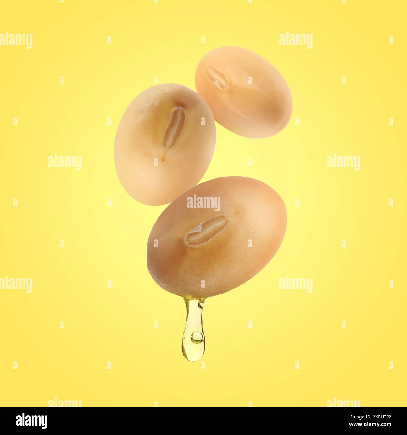 Cooking oil dripping from soybeans on yellow background Stock Photo - Alamy
