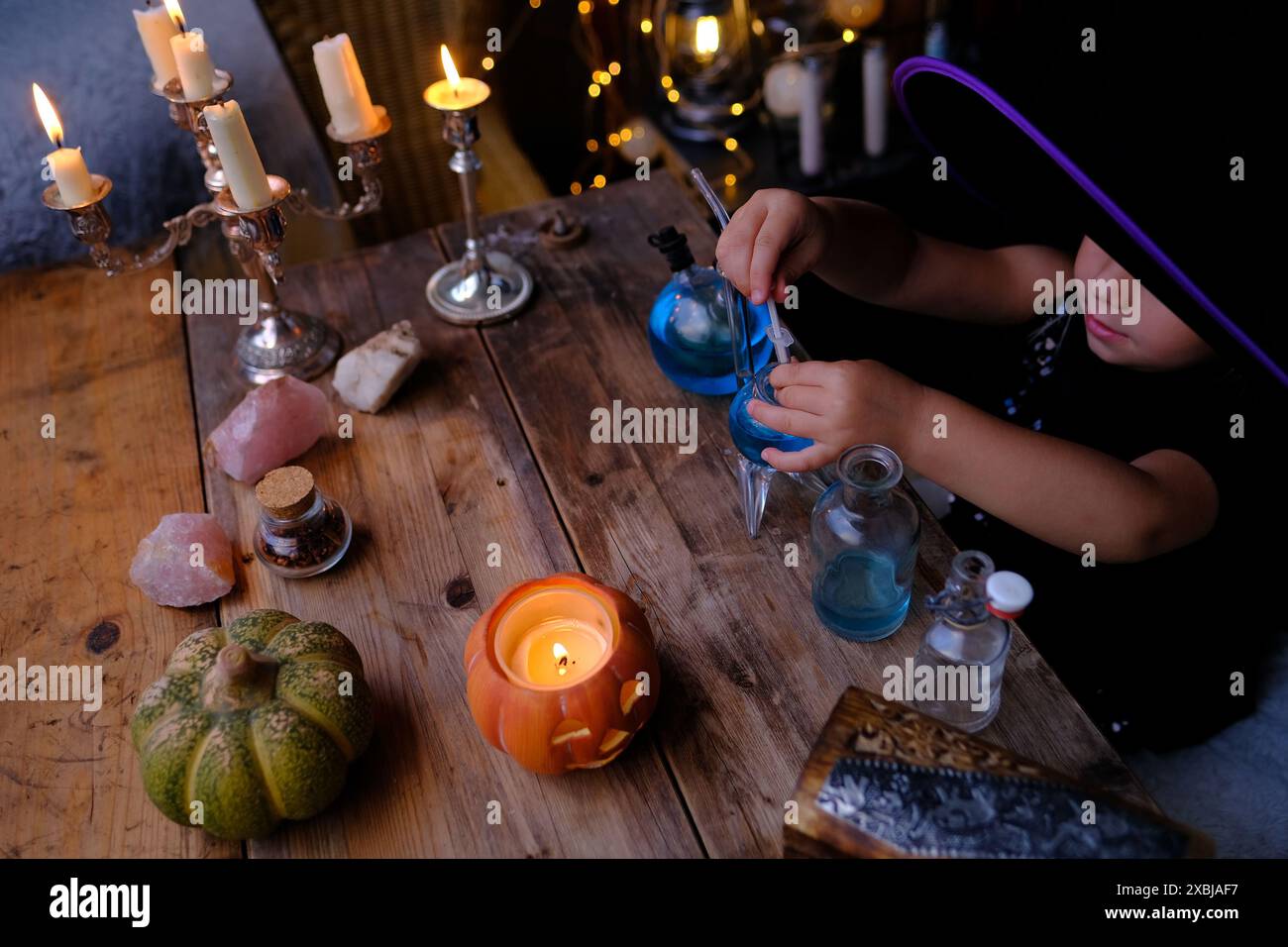 child makes magic out of focus, girl 3 years old in witch hat learns ...
