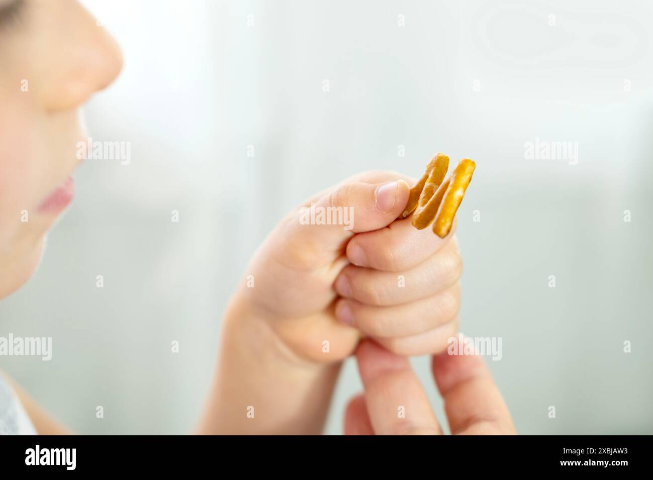 cute cheerful small child, blonde girl 5 years old enjoys crackers in ...