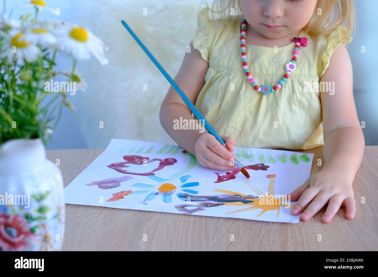 small child, little girl preschooler 3 years paints with brush bright ...