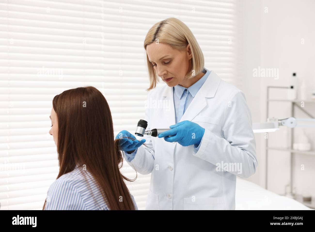 Trichologist with dermatoscope examining patient`s hair in clinic Stock ...