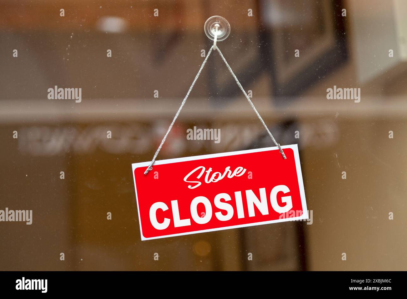 Red sign hanging at the glass door of a shop saying in English: "Store ...