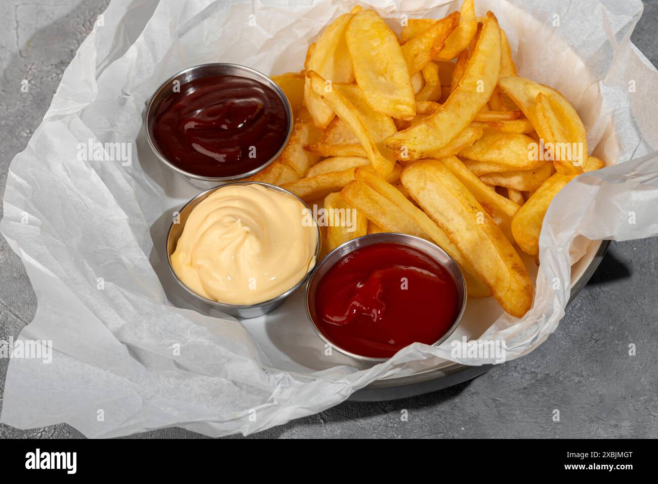 Fried French fries with three sauces on craft paper. Fast food. Copy ...