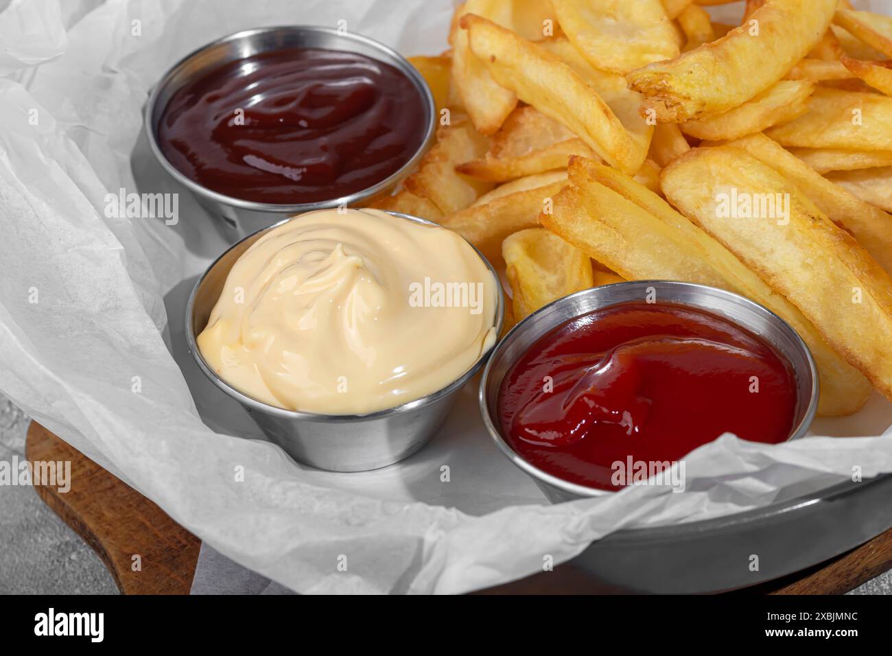 Fried French fries with three sauces on craft paper. Fast food. Copy ...