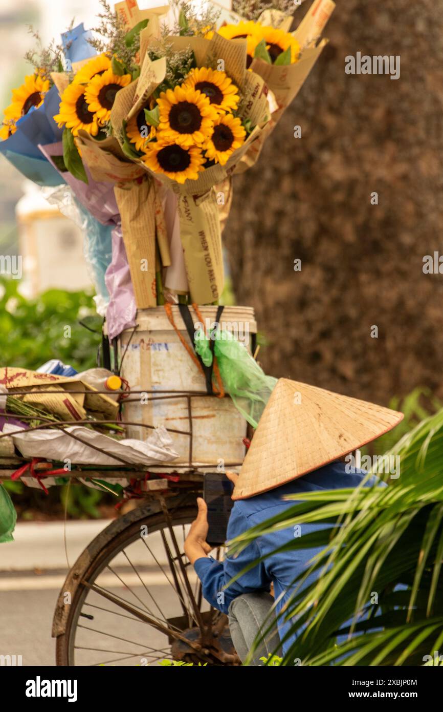 Traditional Hanoi Old Town flower entrepreneur, looking away from ...