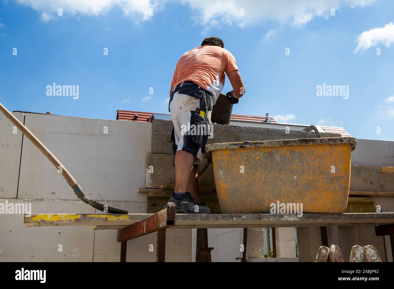 Bricklayer working on the construction site for a new detached house ...