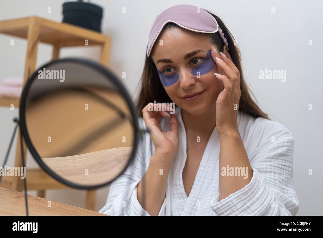 Eye Patch Magic: woman morning looks in the mirror, applying under-eye ...