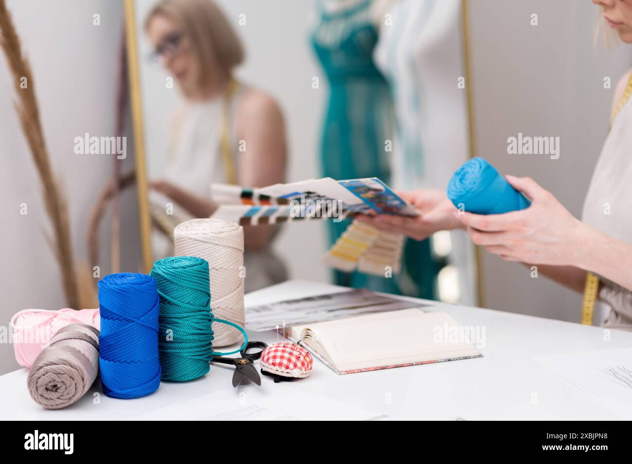 Fashion designer chooses thread color with palette in dressmaking ...