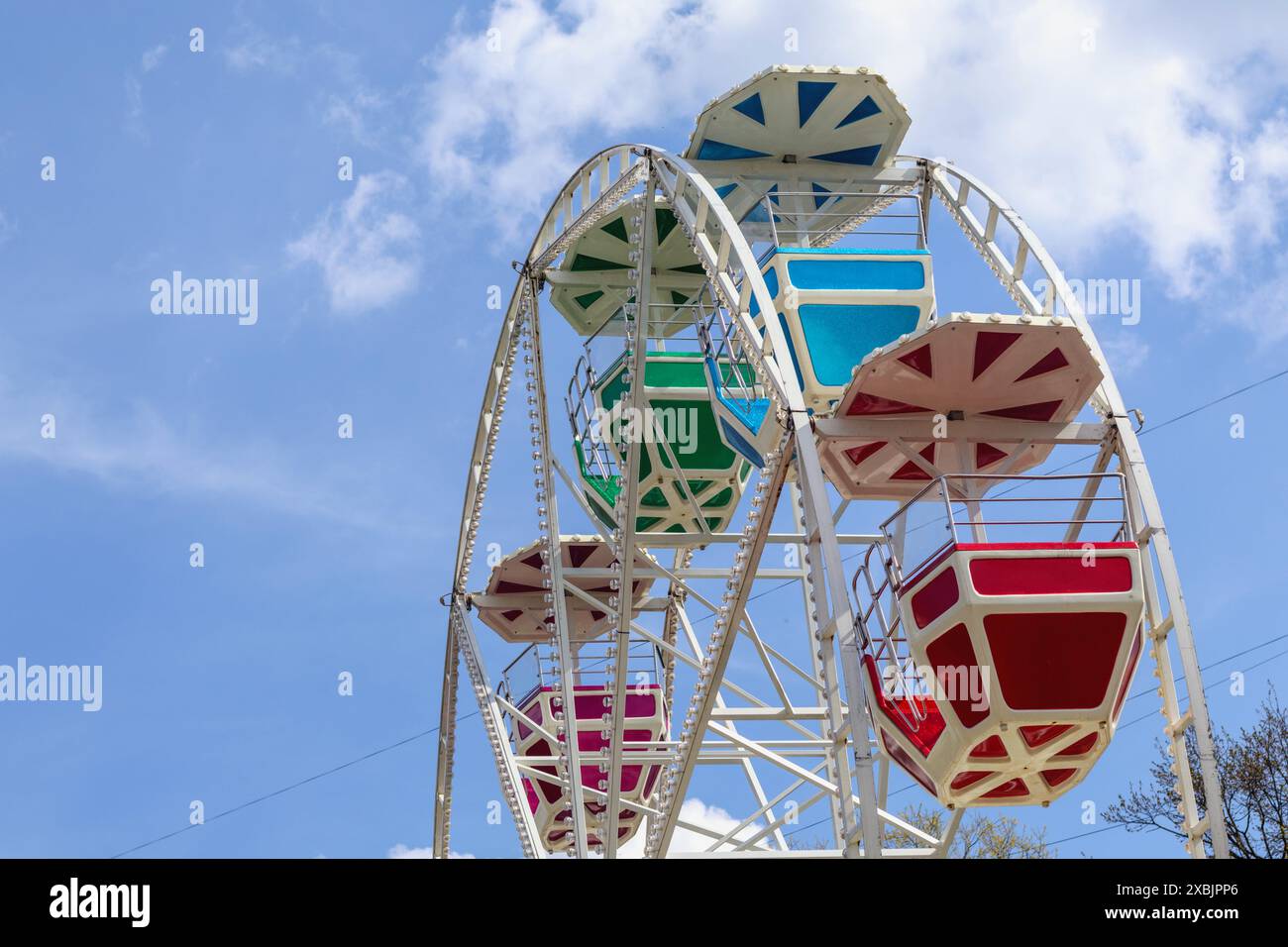 Colorful children's ferris wheel in the day on a blue sky background ...