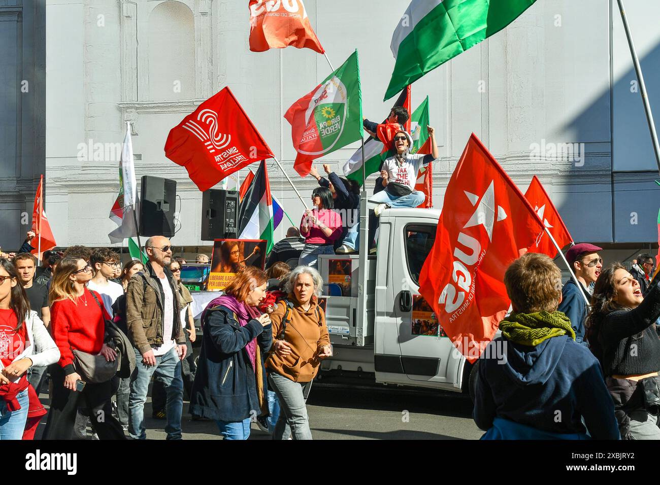 Demonstrators walking and over a van with political flags at the ...