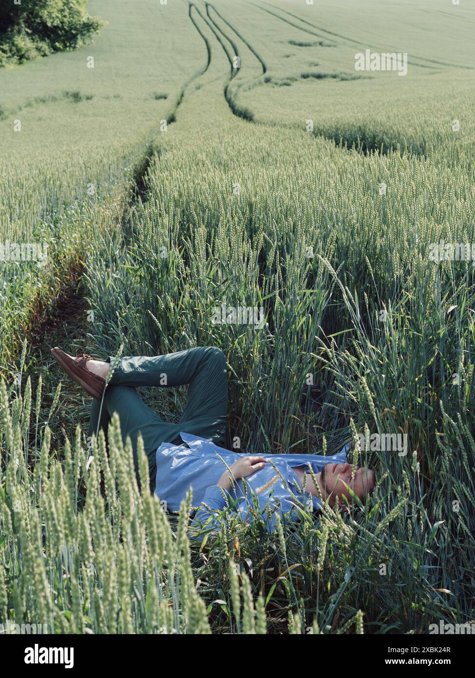 Daydreaming: Vertical wide angle portrait of a young man laying down on ...