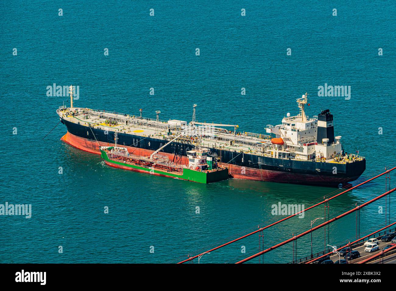 Oil tanker receiving fuel from bunkering tanker in the port Stock Photo ...